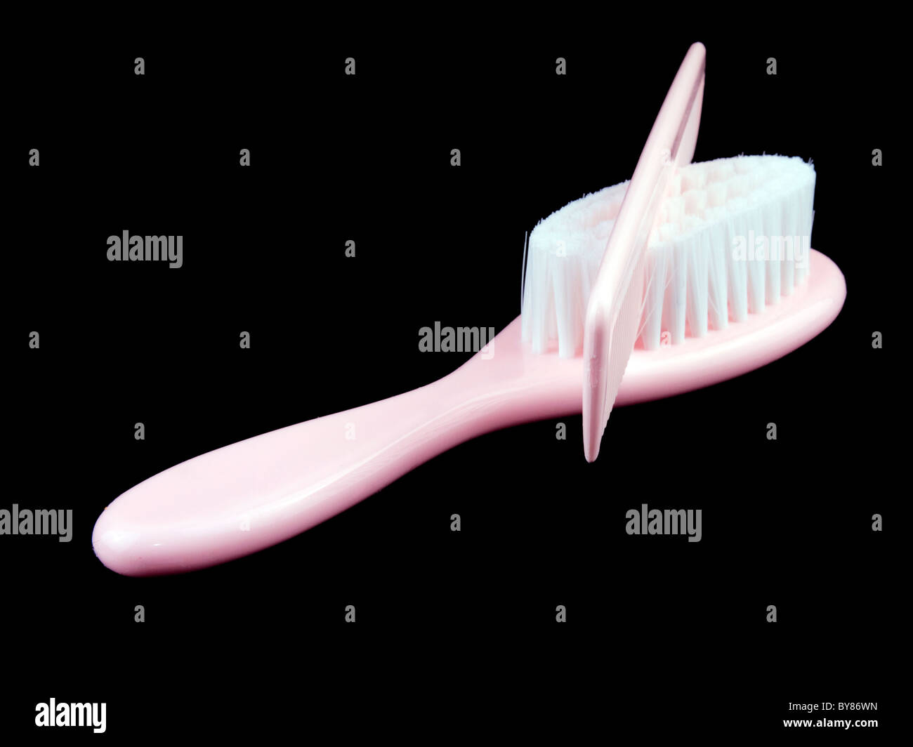 Little pink hair-brush and pink comb for newborn baby on black ...