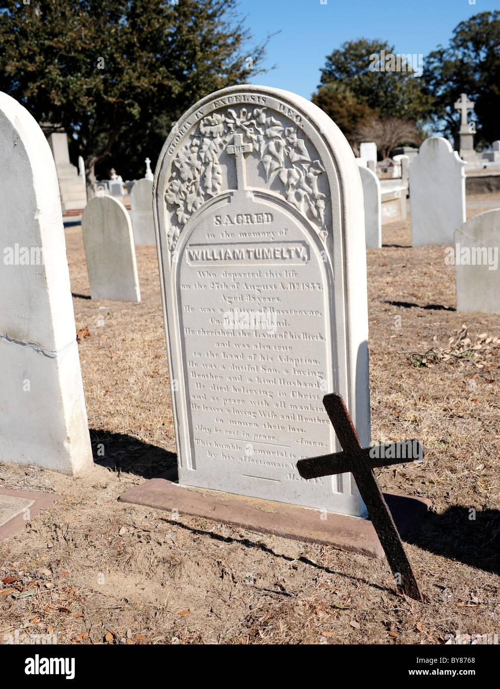 Black iron cross with white Victorian tombstone Stock Photo - Alamy