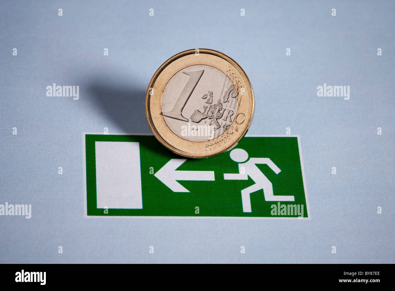 One Euro coin on an emergency exit direction sign Stock Photo - Alamy