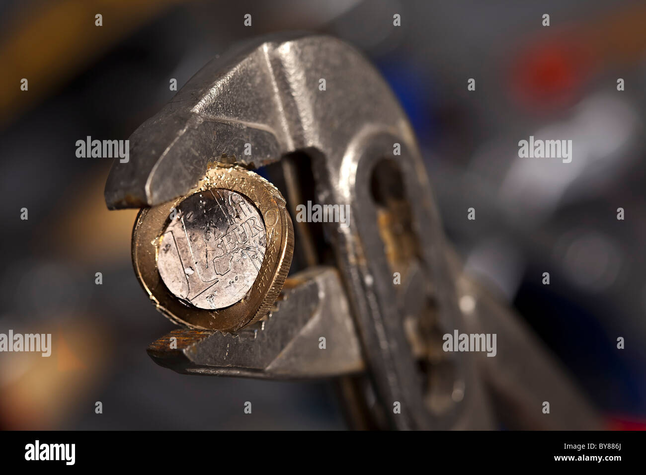 Broken one Euro coin in a pair of pliers Stock Photo - Alamy