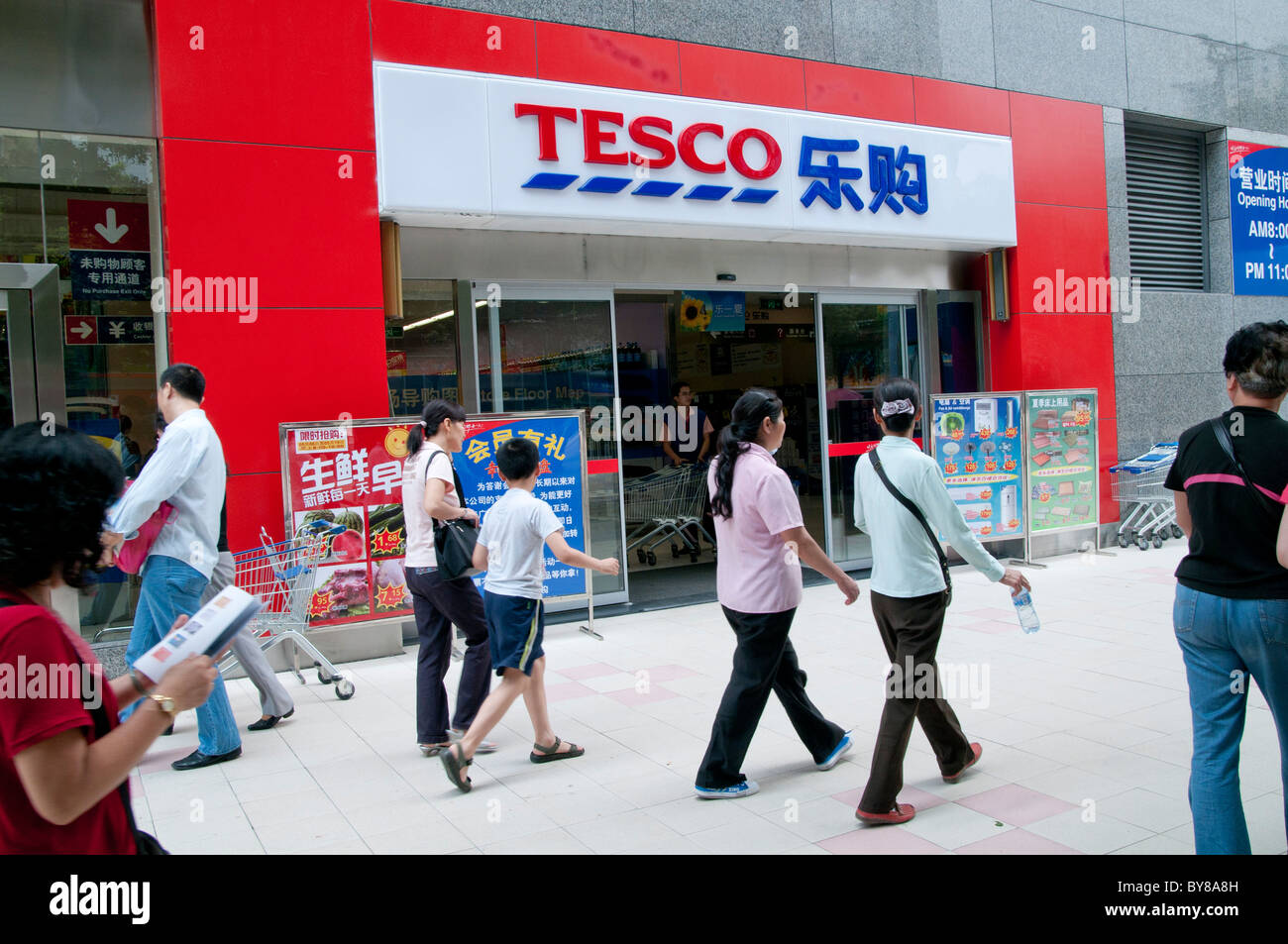 CHINA Shoppers walking past a Tesco store in Guangzhou Guangdong ...