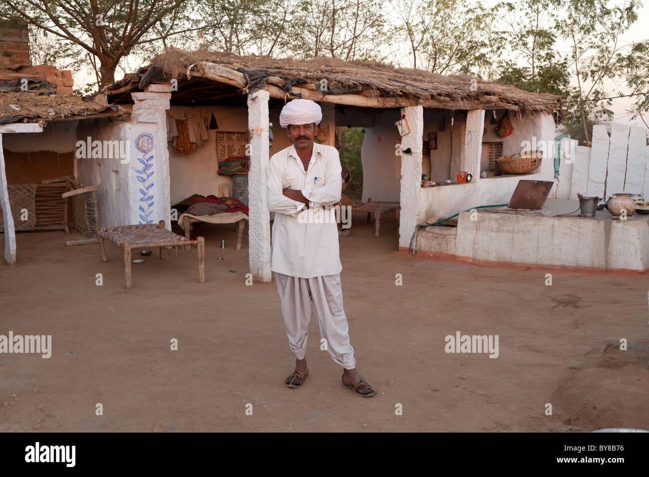 India, Rajasthan, Jodhpur, Village man standing outside his home posing ...