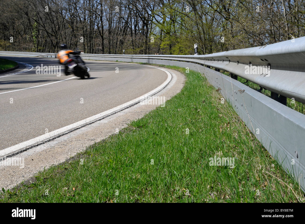 Motorcycle rider on country road with crash barrier protection Germany ...