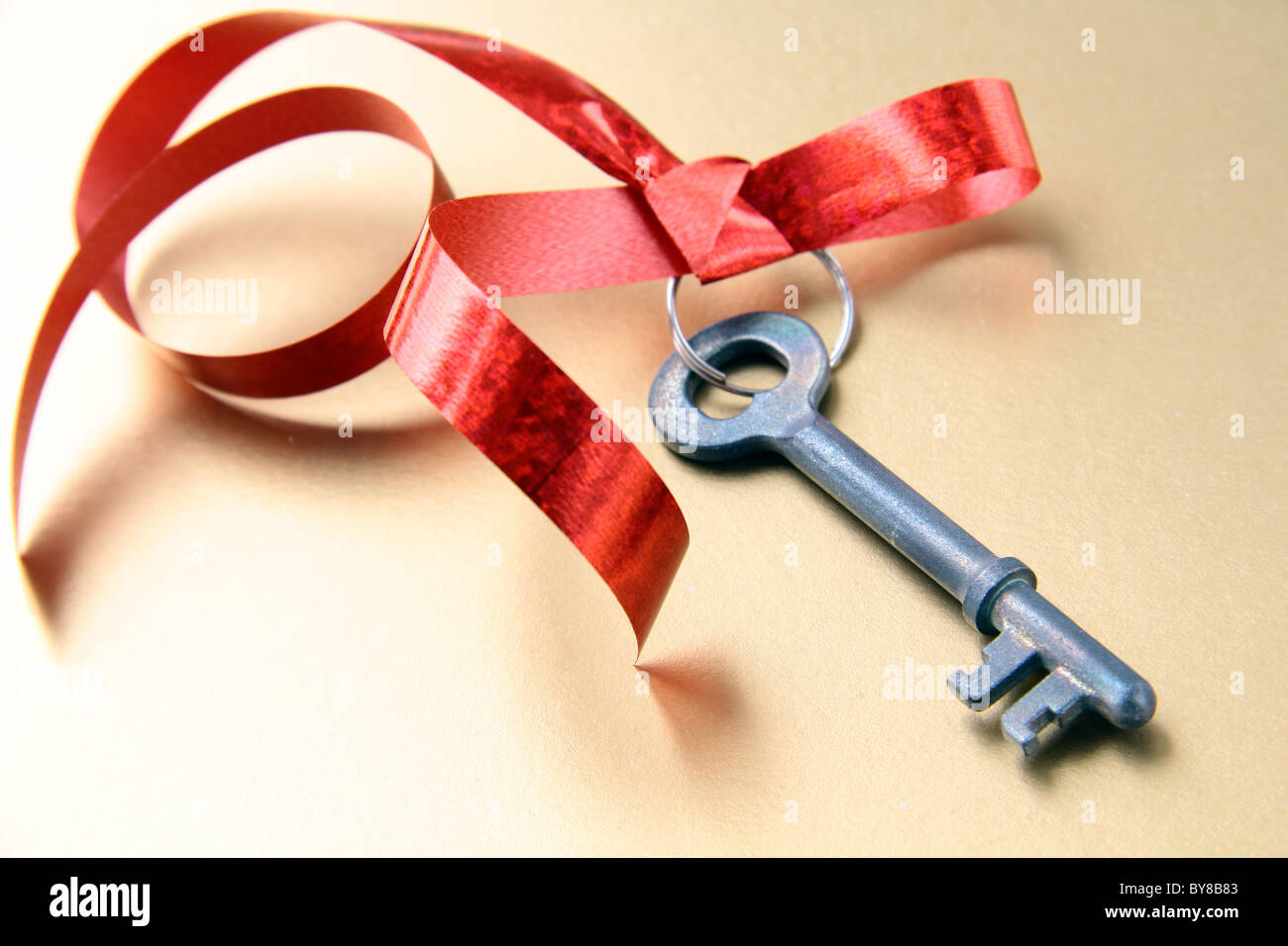 old key with a red ribbon on gold background Stock Photo - Alamy