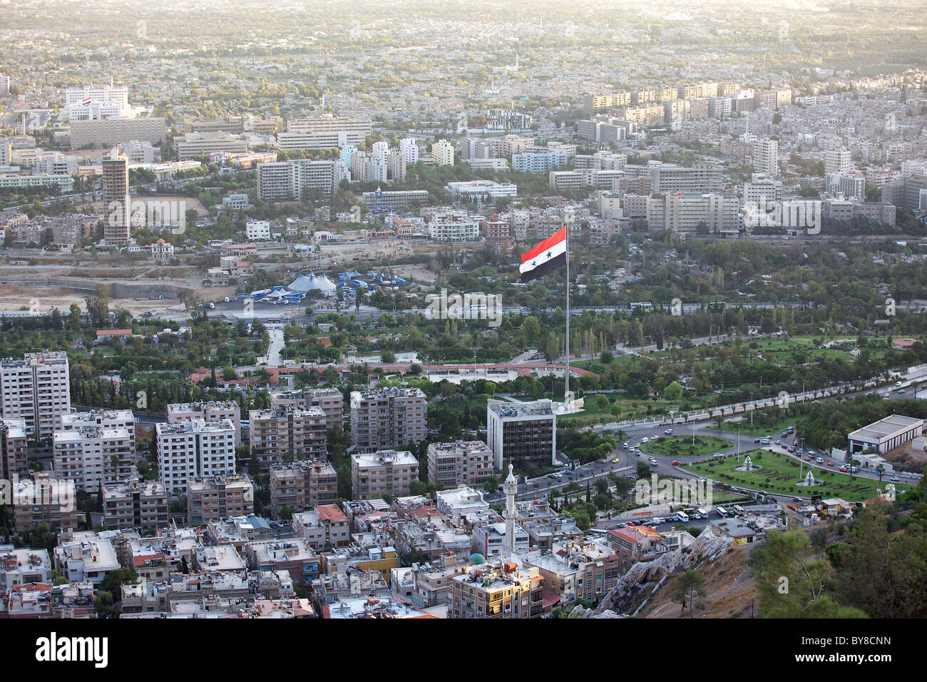An enormous Syrian flag flutters over the Western precincts of Damascus ...