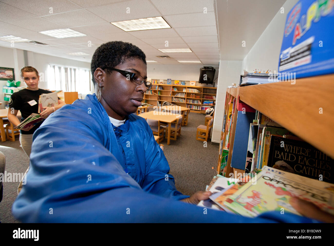 Volunteers Organize Books in School Library Stock Photo - Alamy