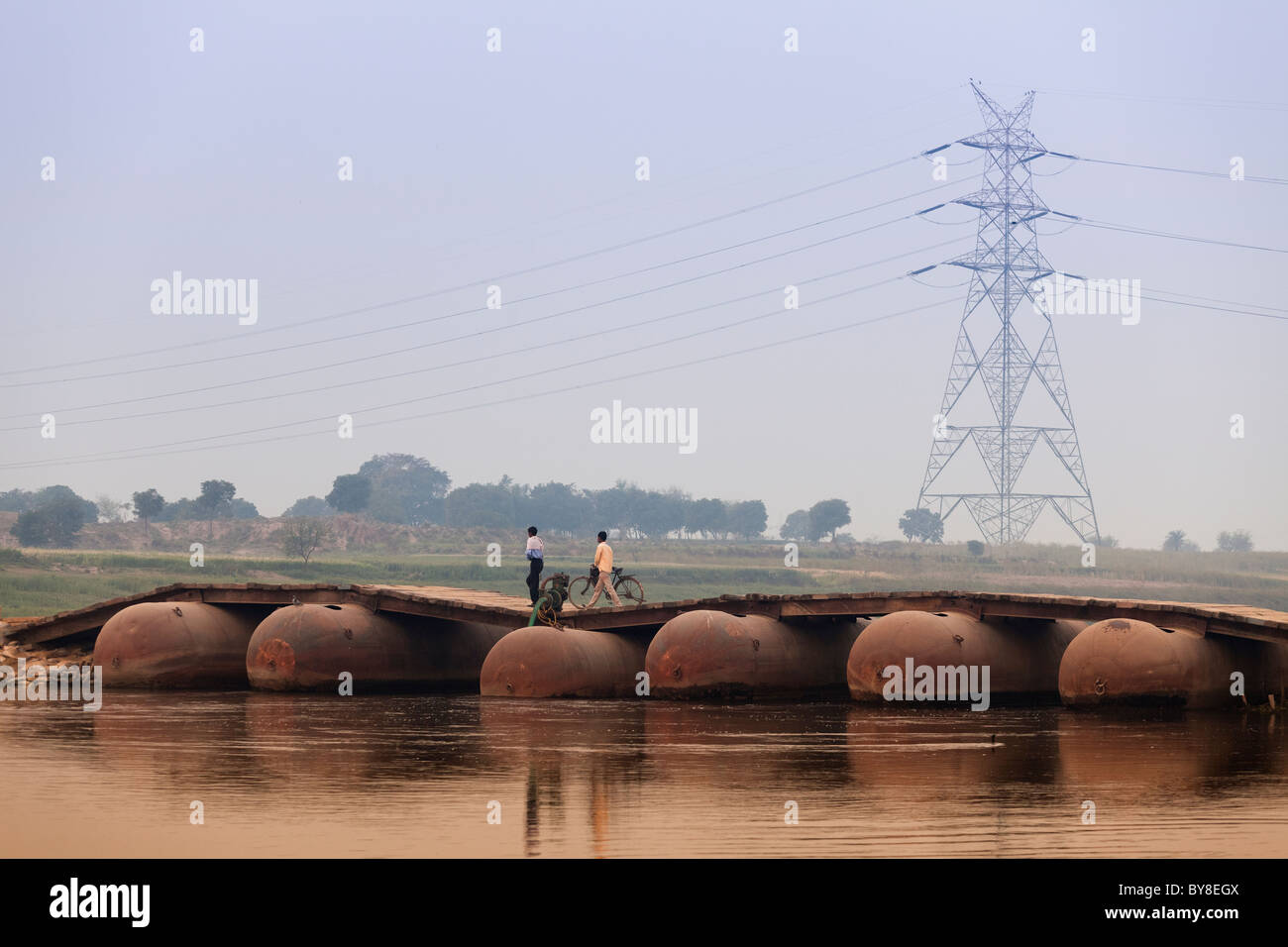 India, Uttar Pradesh, Agra, two men crossing pontoon bridge over Yamuna ...