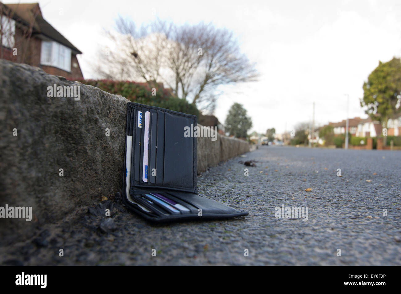a lost or stolen wallet lays on the pavement Stock Photo - Alamy