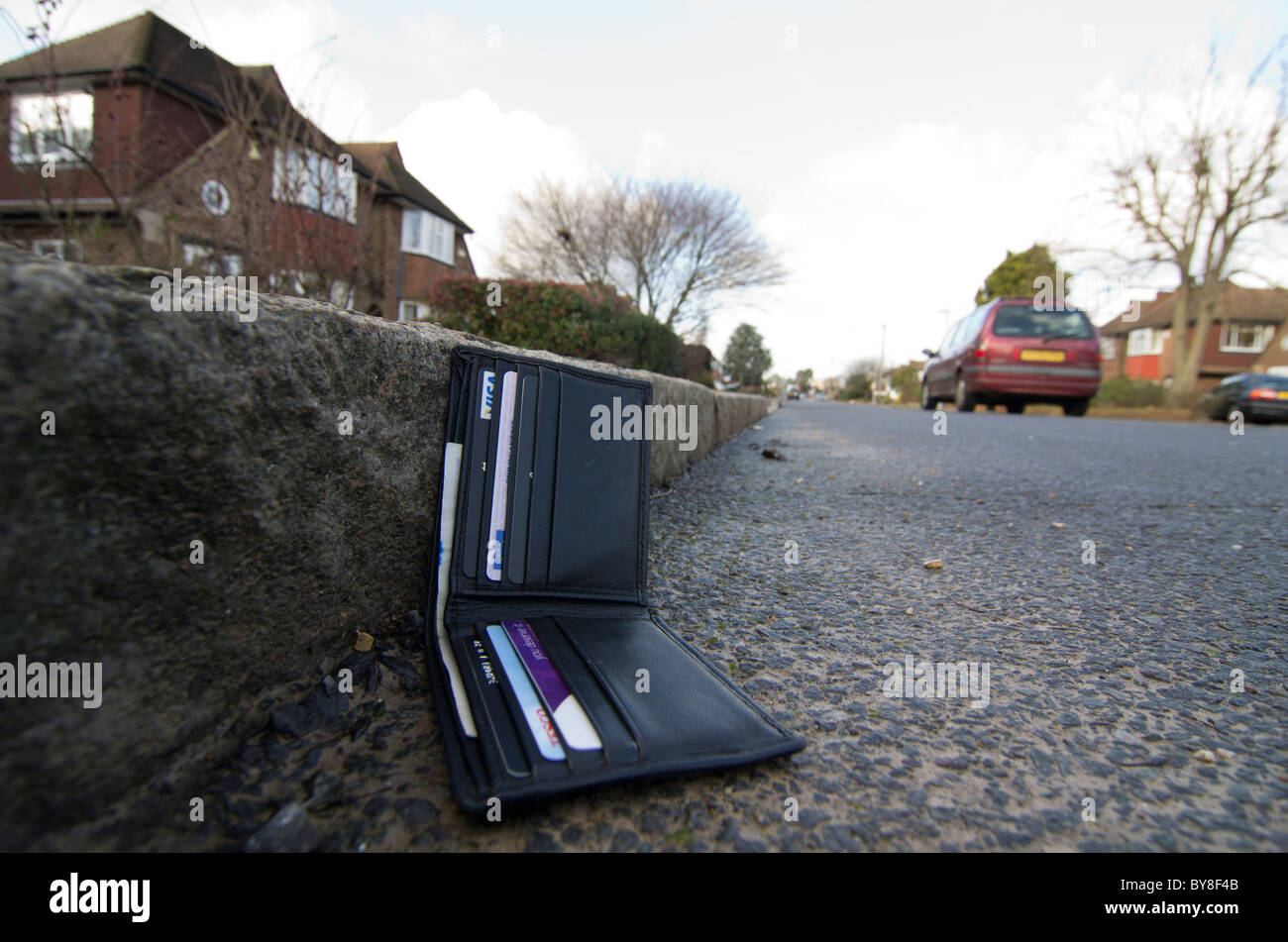 a lost or stolen wallet lays on the pavement Stock Photo - Alamy