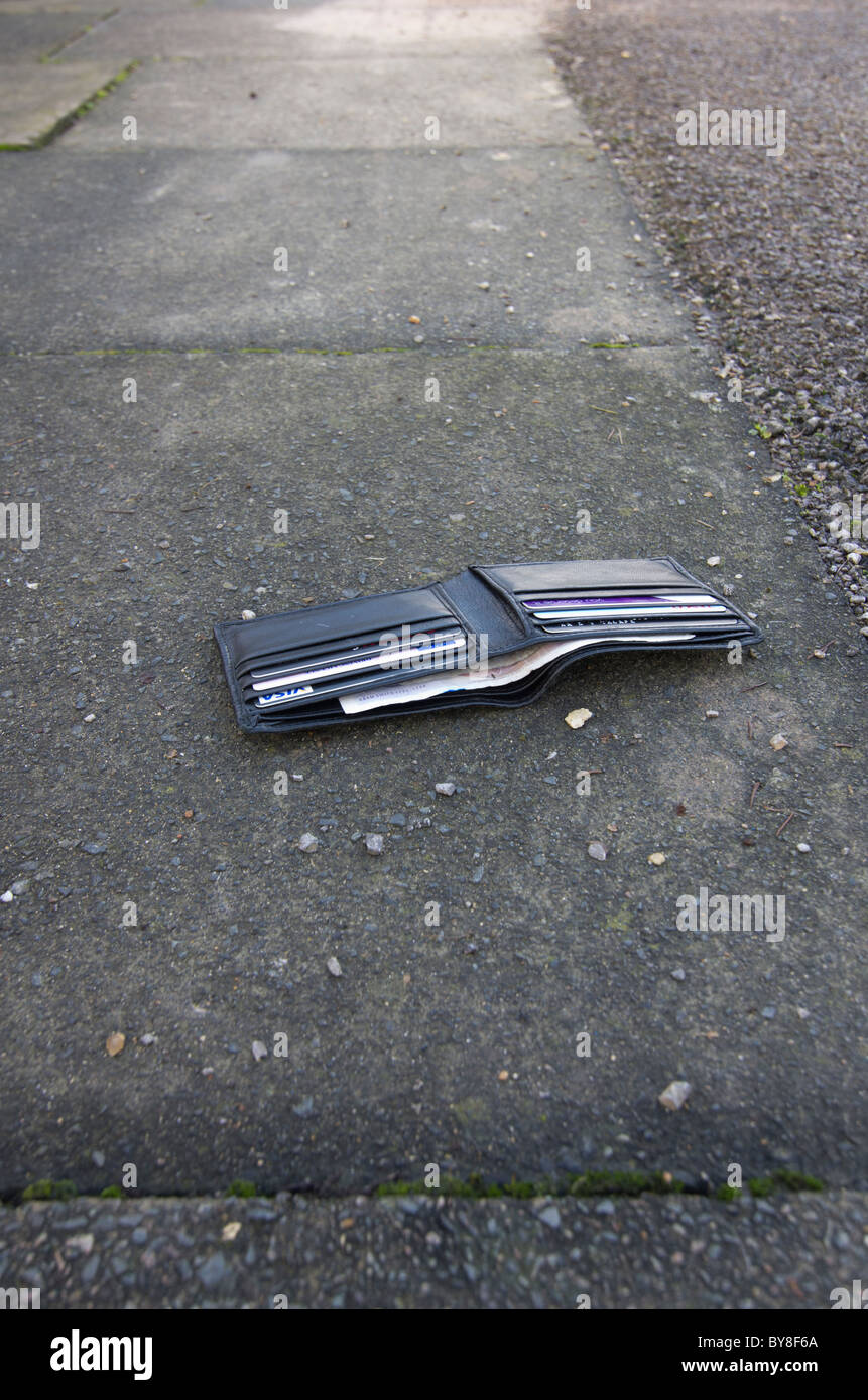 a lost or stolen wallet lays on the pavement Stock Photo - Alamy