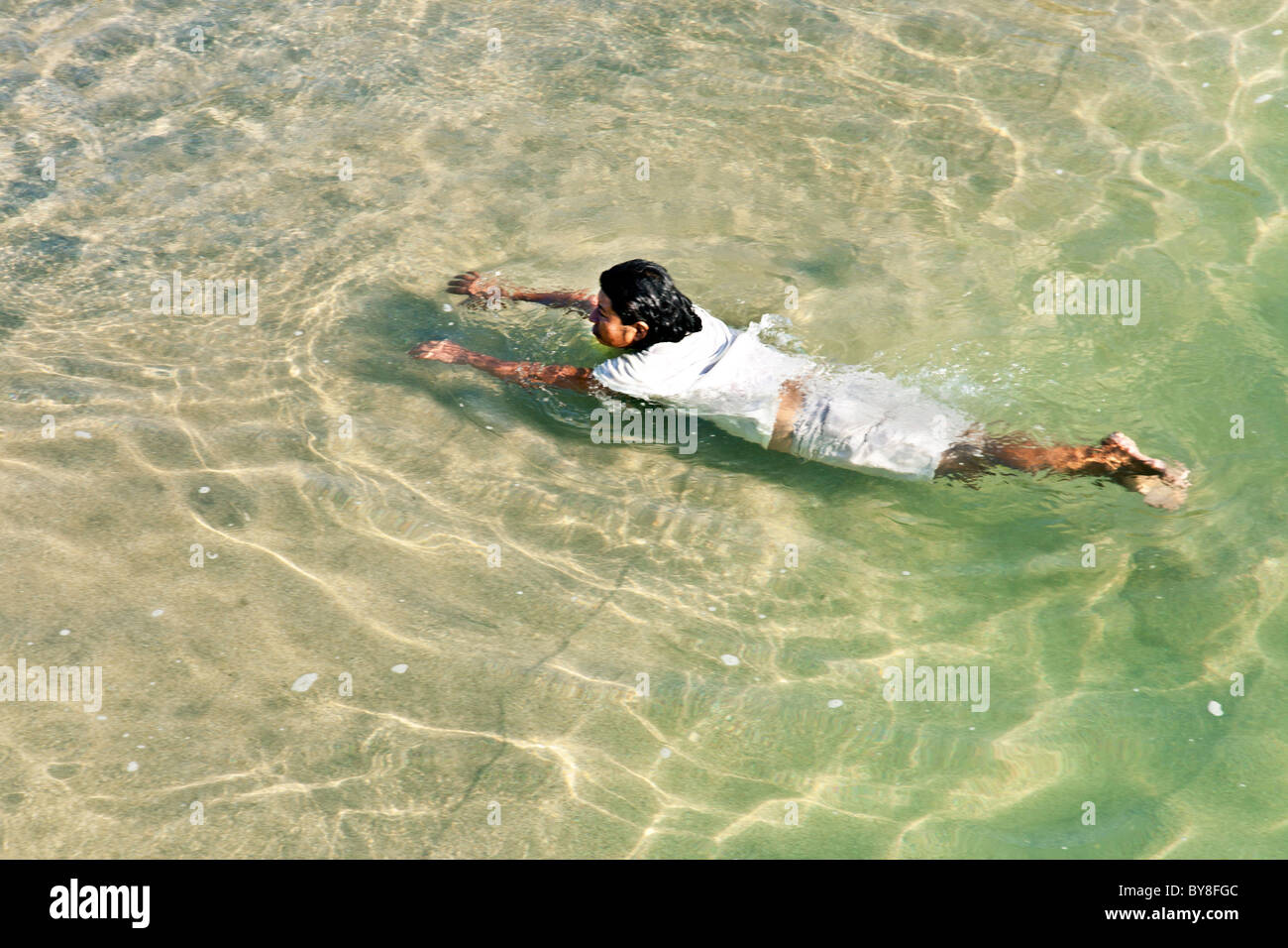 Mexican woman wearing skirt & tee shirt swimming in transparent ocean ...