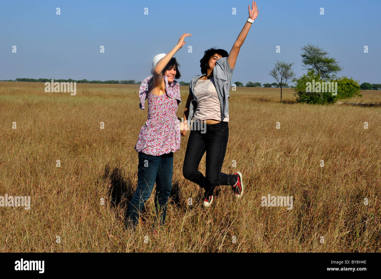 Two indian girls jumping in a wild life sanctury, india Stock Photo - Alamy