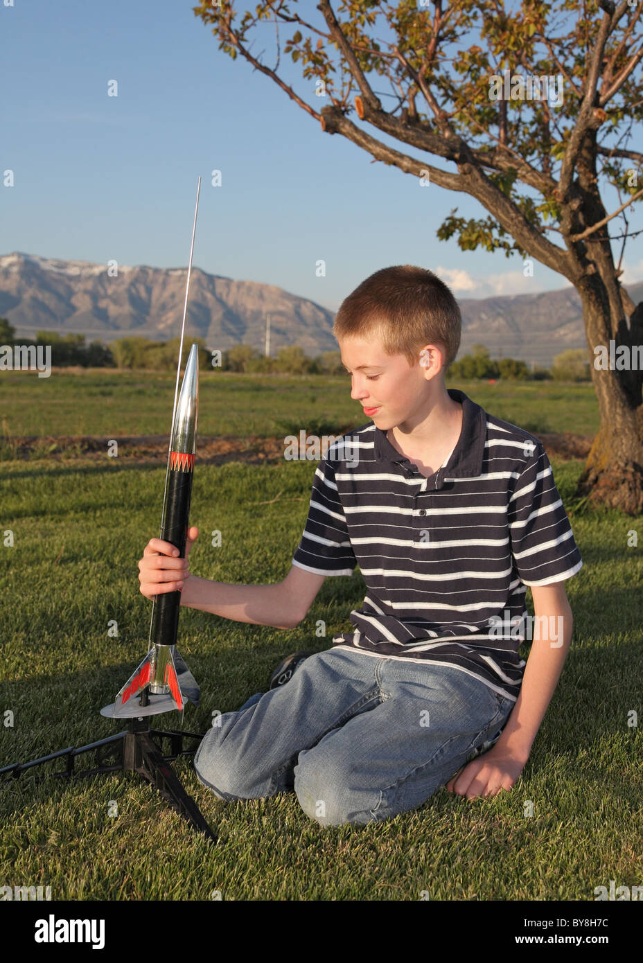 twelve year old boy playing with model rocket in countryside Stock ...