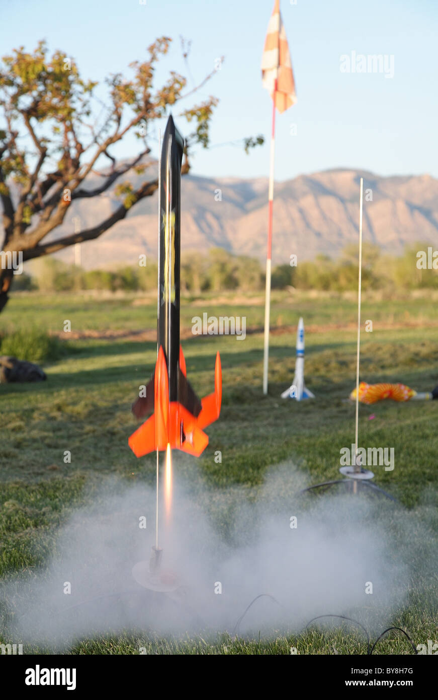 colorful model rocket launching off grass Stock Photo - Alamy