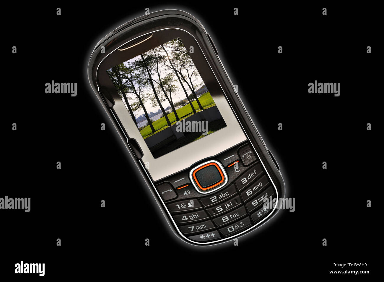 A charcoal-colored cell or feature phone with a glow against a black ...