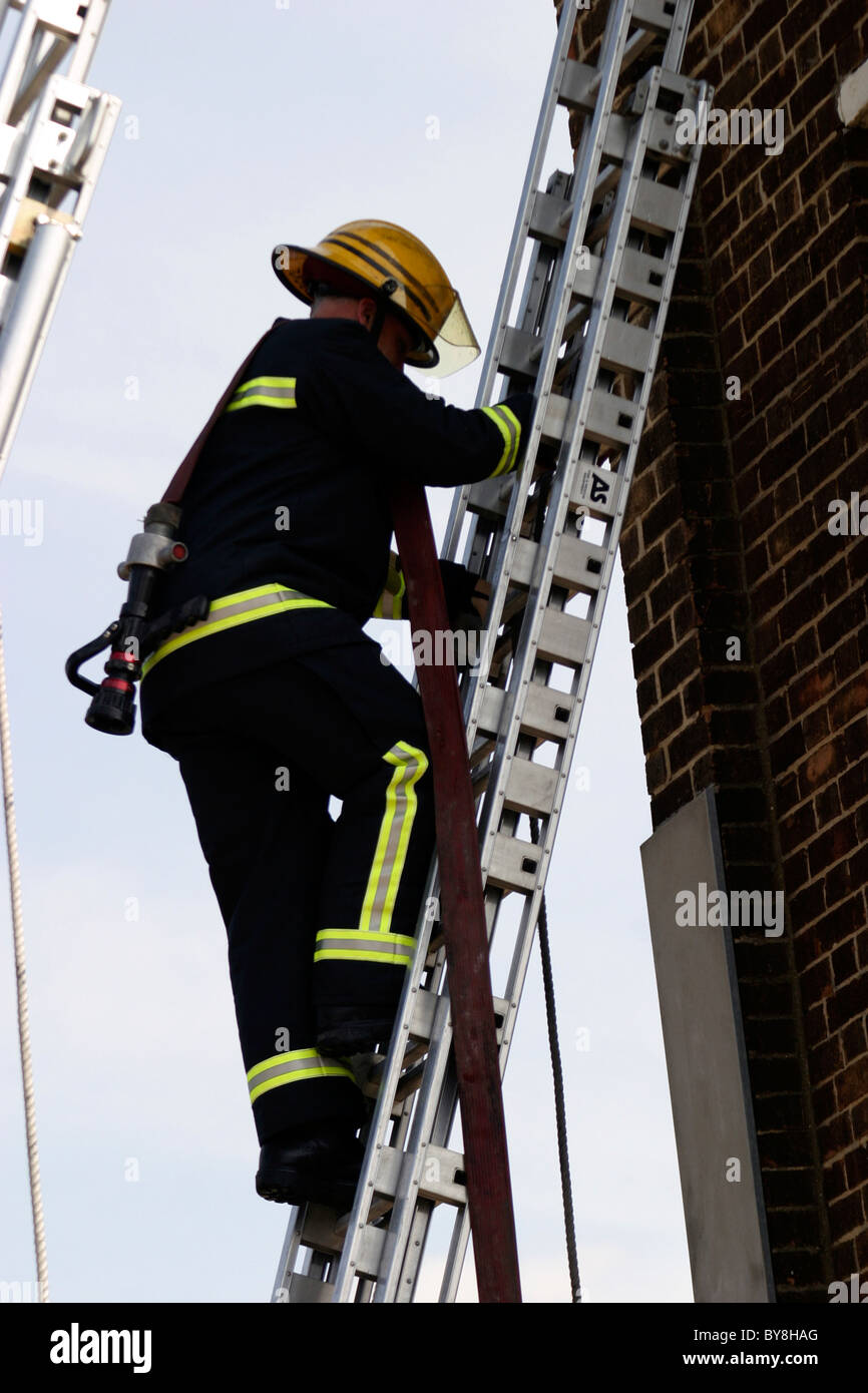 Firefighter ascending a ladder Stock Photo - Alamy