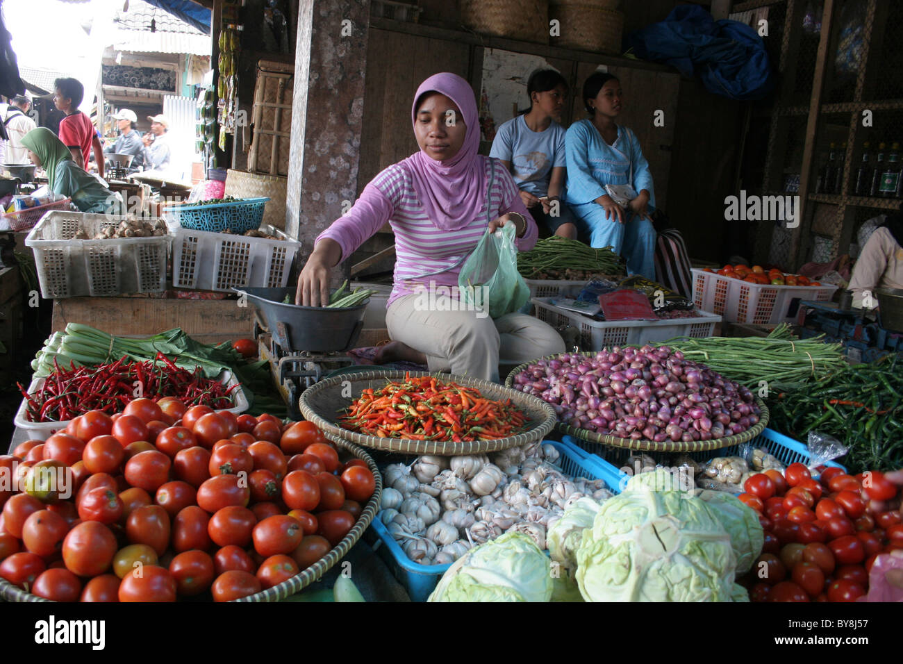 Asian woman selling vegetables at family stall Stock Photo - Alamy