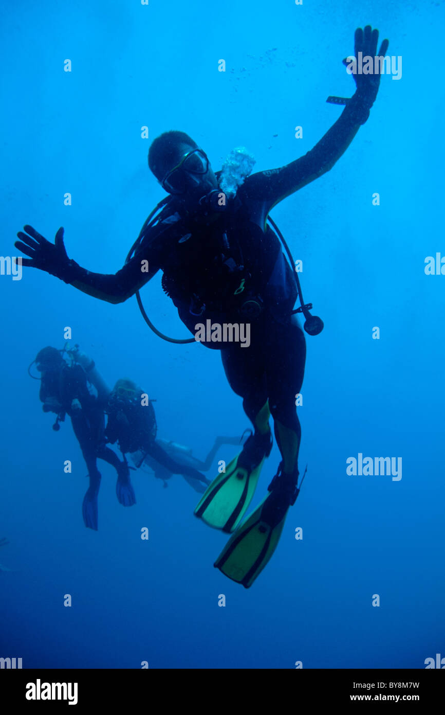 Scuba divers making faces for the camera, Ross Atoll, Maldive Islands ...