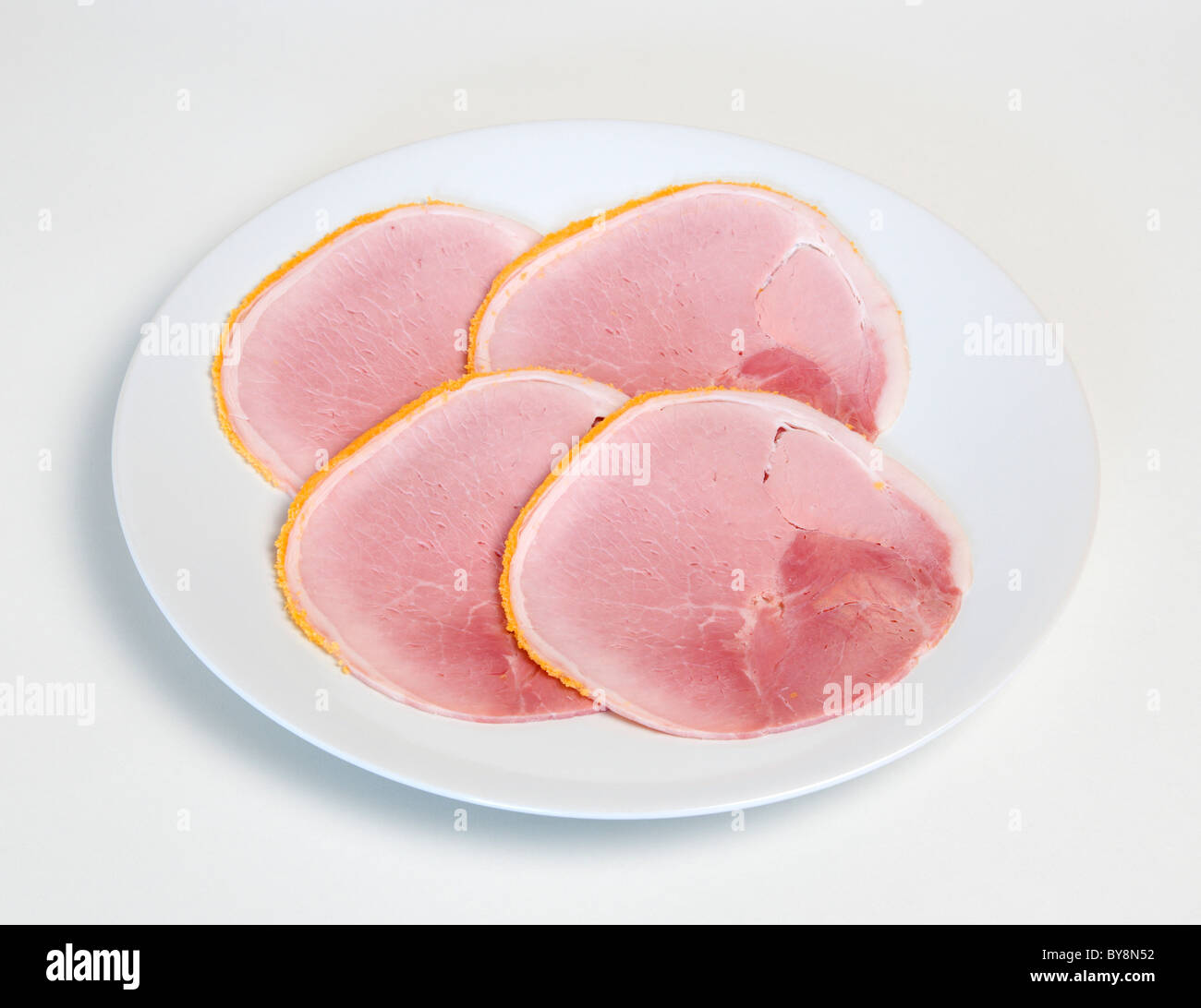 Food Meat Pork Slices of cured ham on a round white plate on a white ...