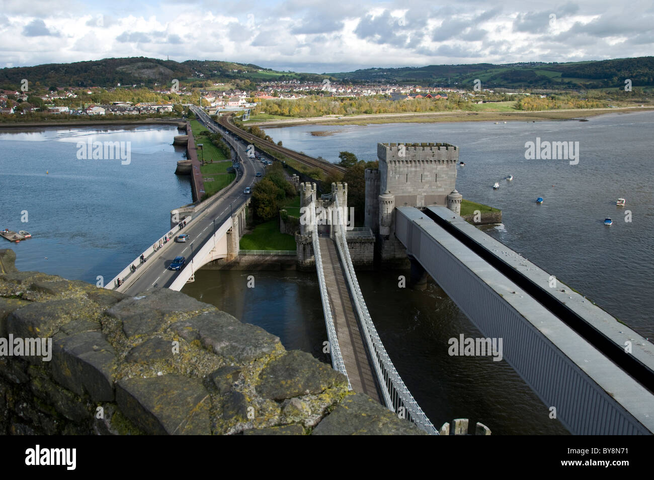 The suspension bridge, railway bridge and causeway from Conwy Castle ...