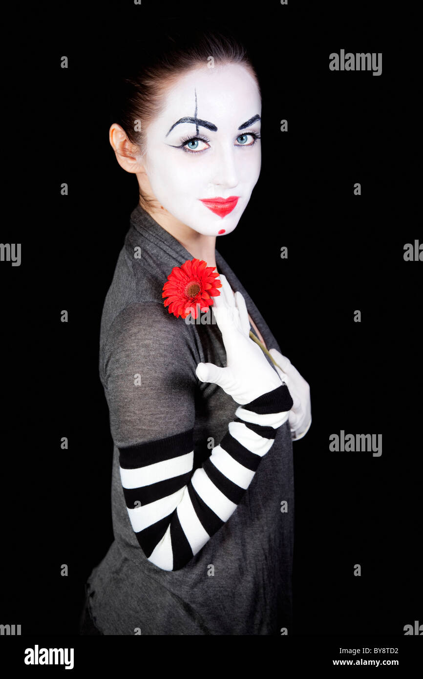 woman mime with red flower on black background Stock Photo - Alamy