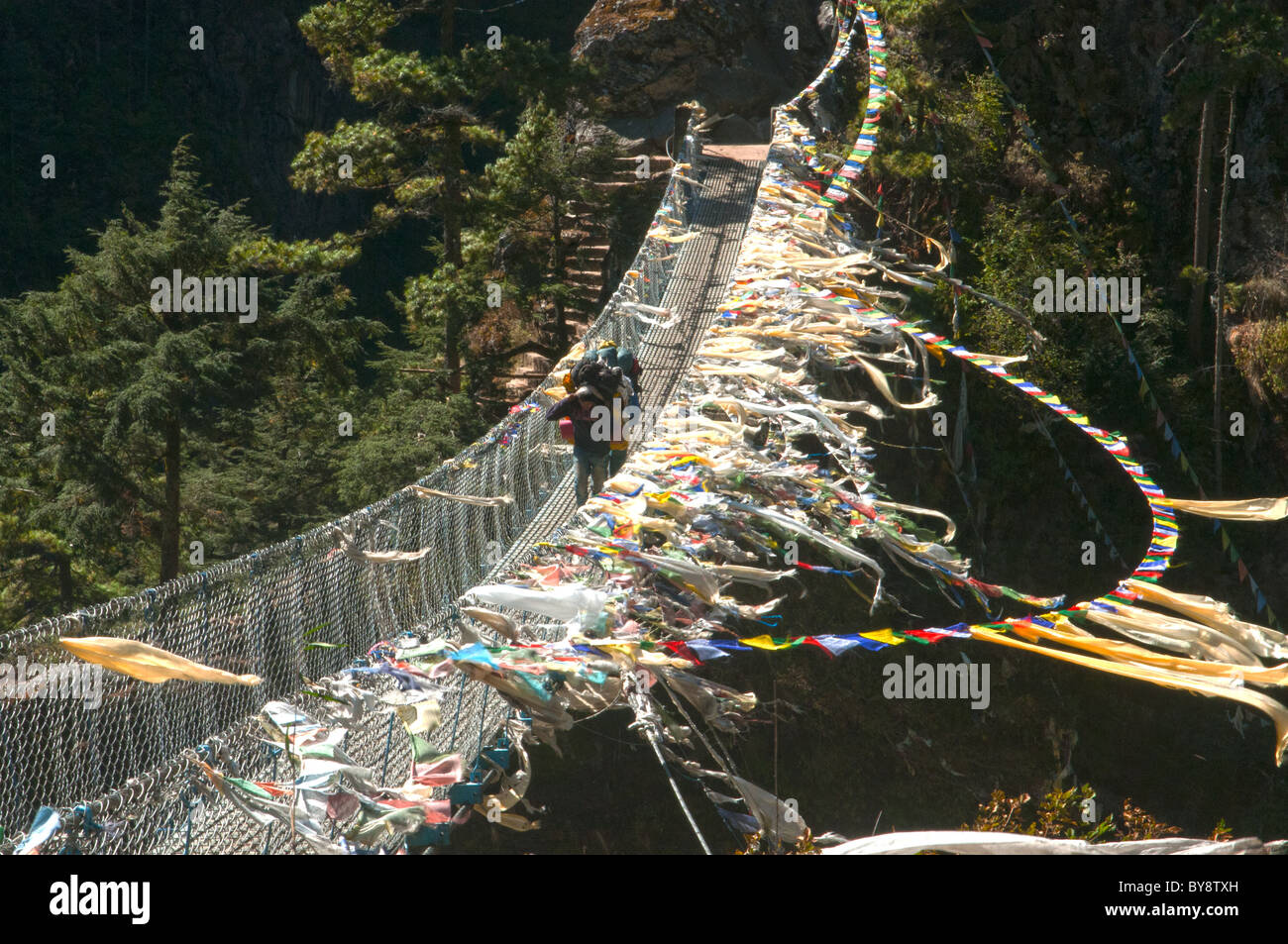prayer flags blowing on suspension bridge crossing in the Everest ...