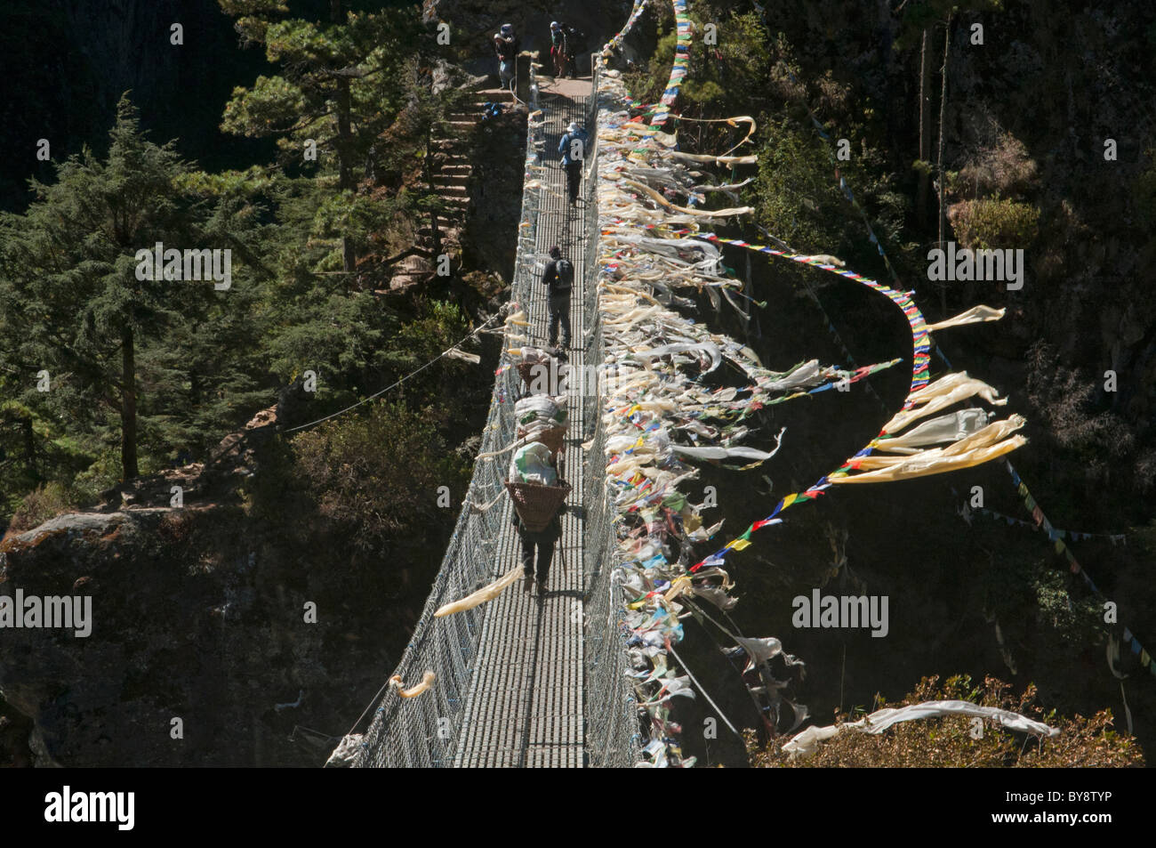 prayer flags blowing on suspension bridge crossing in the Everest ...