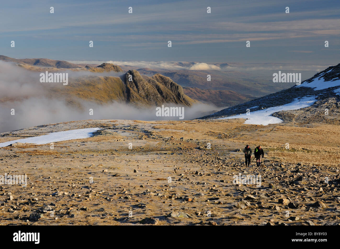 Walkers on Esk Hause with the Langdale Pikes rising above the cloud in ...