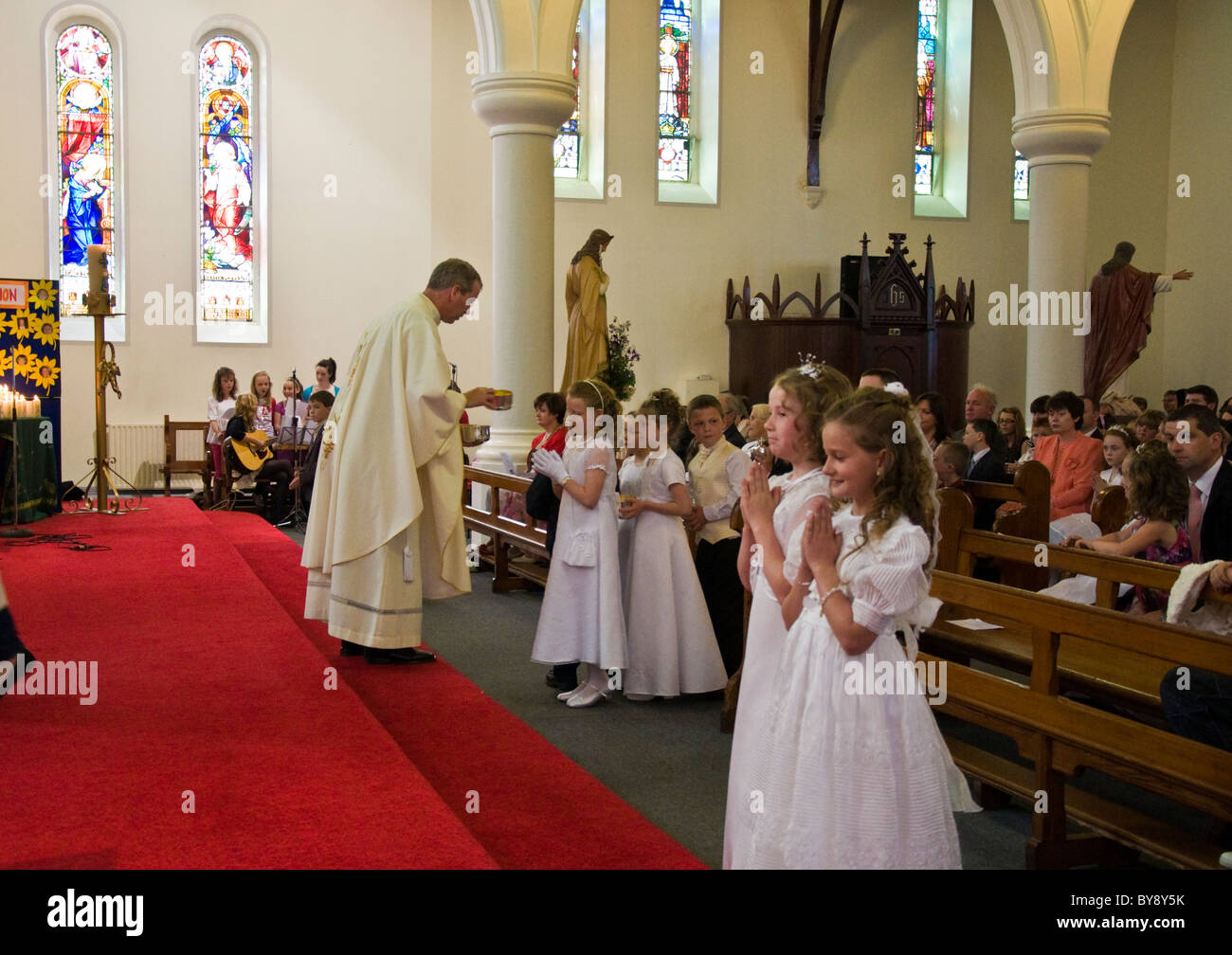 Children in a Roman Catholic church take their First Communion Stock ...