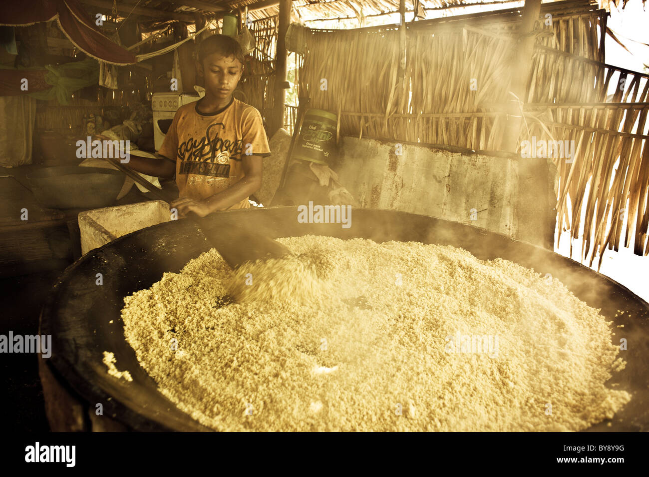A boy roasting manioc flour in the Amazon Rainforest Stock Photo - Alamy