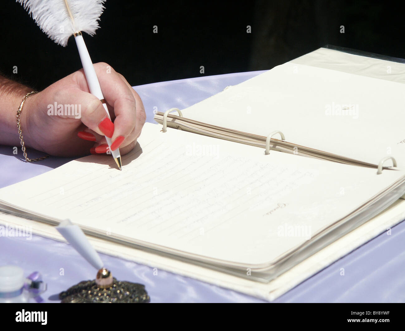 Guest at a wedding signing the wedding guestbook Stock Photo - Alamy