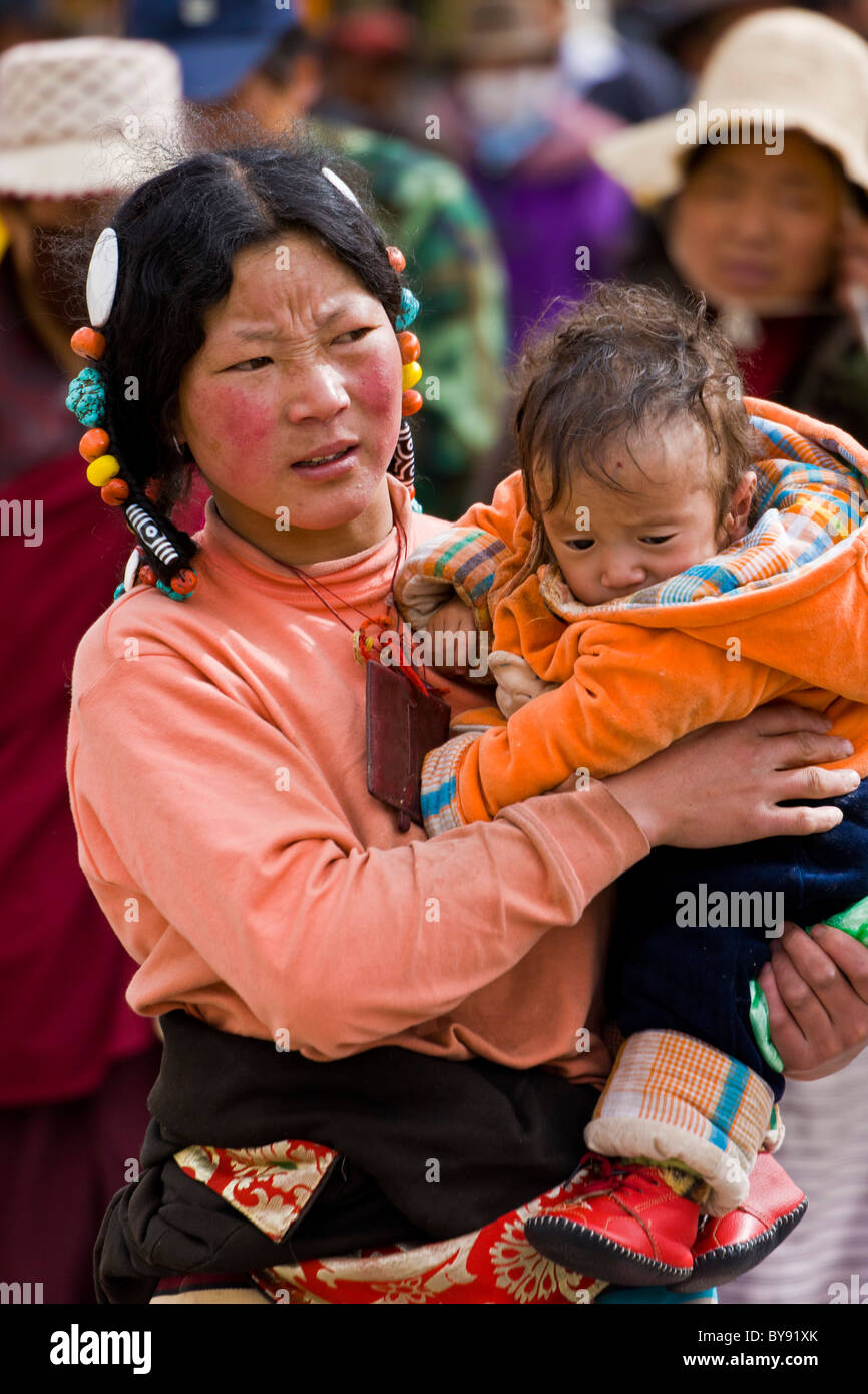 Tibetan women pilgrim carrying baby in the Barkhor, Lhasa, Tibet ...