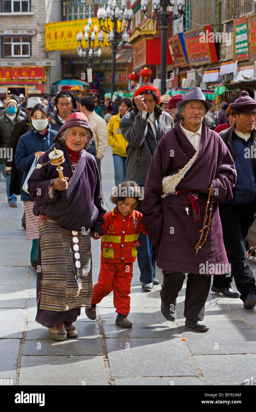 Family group of Tibetan pilgrims walking in the Barkhor, Lhasa, Tibet ...