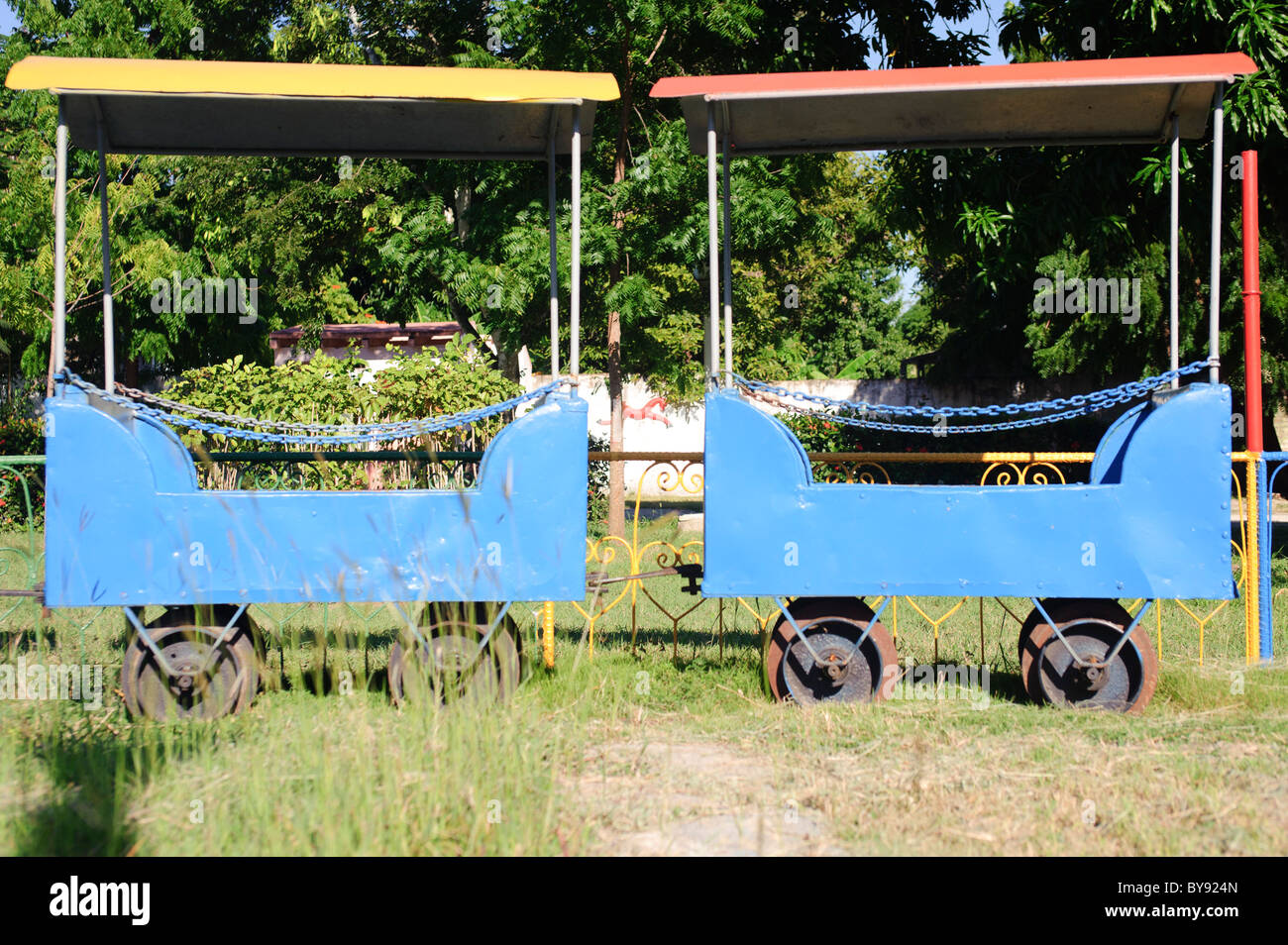 Blue Wagons for roundabout for kids in garden in Cuba Stock Photo - Alamy