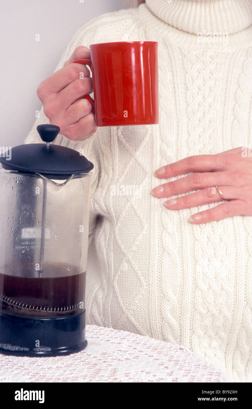 pregnant woman drinking pot of coffee Stock Photo - Alamy