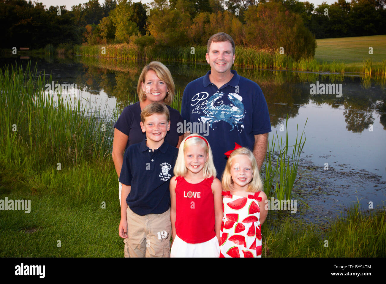 A happy family at a park outside with pond Stock Photo - Alamy