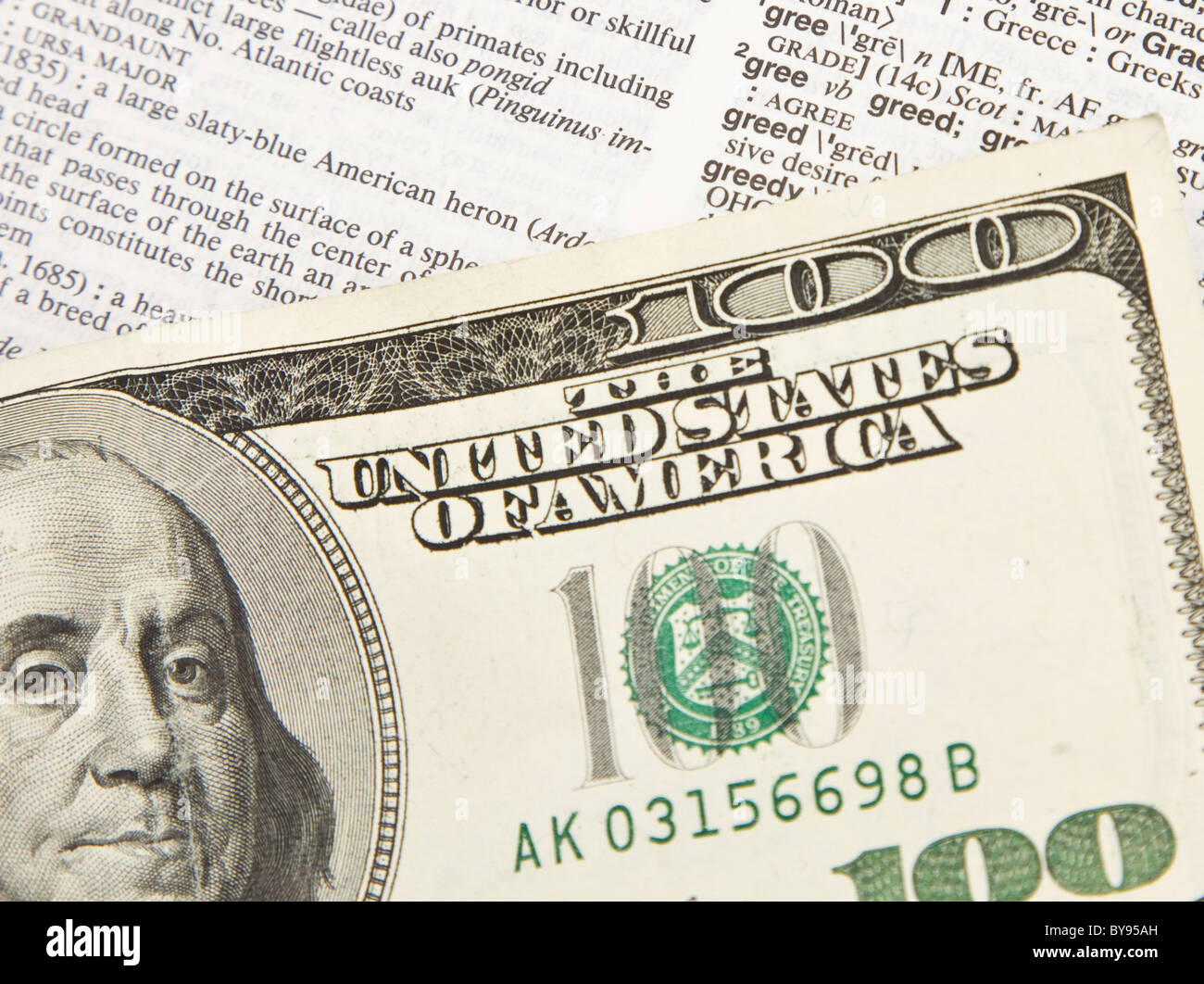 Closeup of 100 dollar bill and greed in dictionary Stock Photo - Alamy