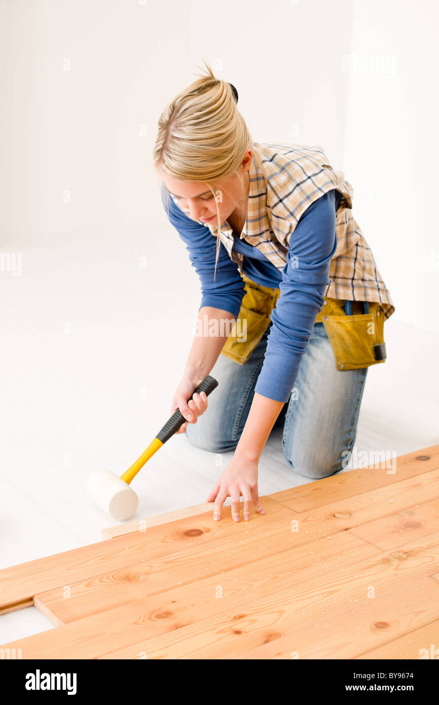 Home improvement - handywoman installing wooden floor home Stock Photo ...