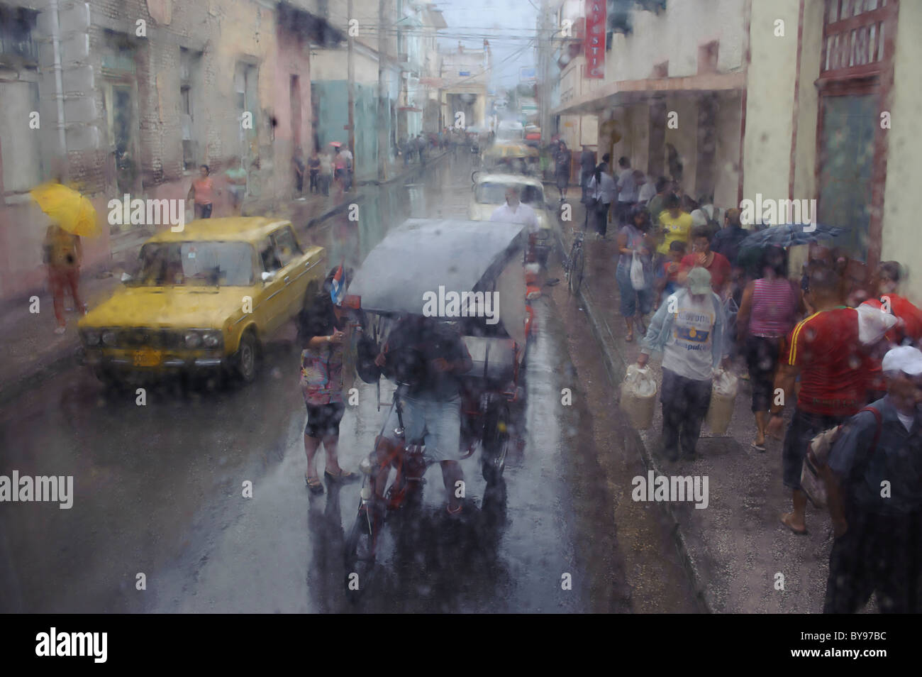 Street of Holguin CUBA during a rainy day with crowd and bicitaxi ...