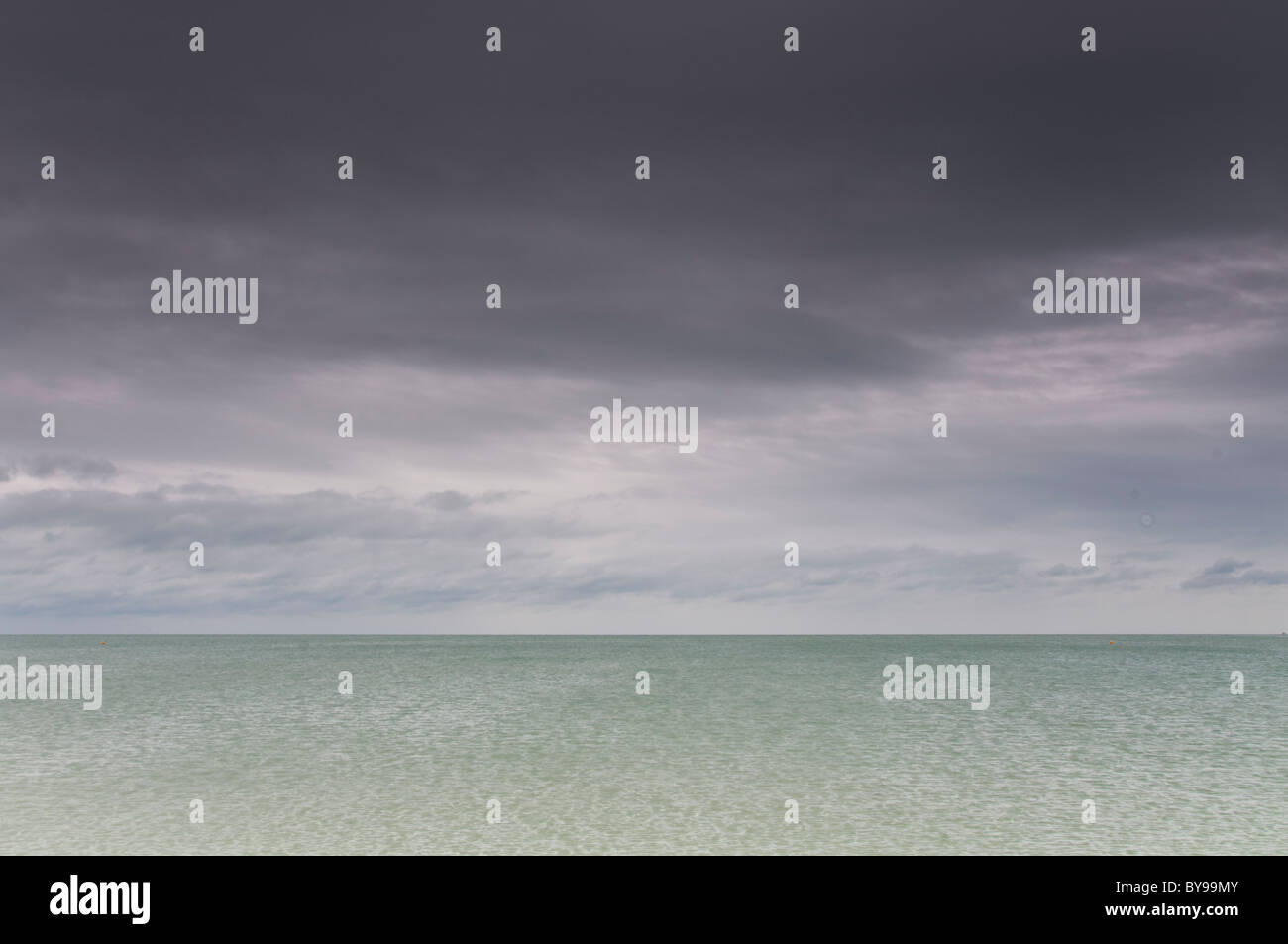 Calm sea with horizon and dark clouds Stock Photo - Alamy