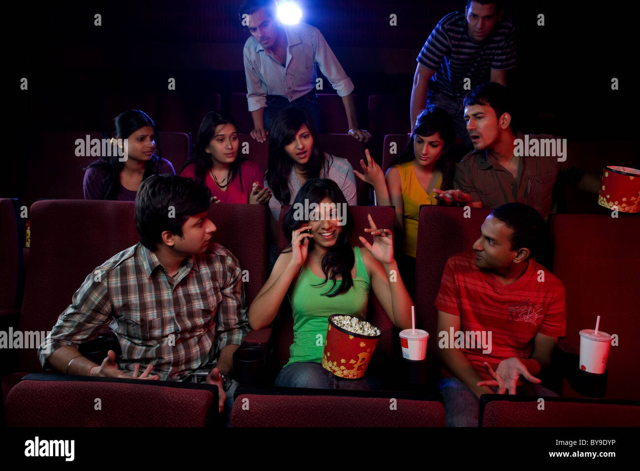 Girl talking on a mobile phone in a cinema hall Stock Photo - Alamy