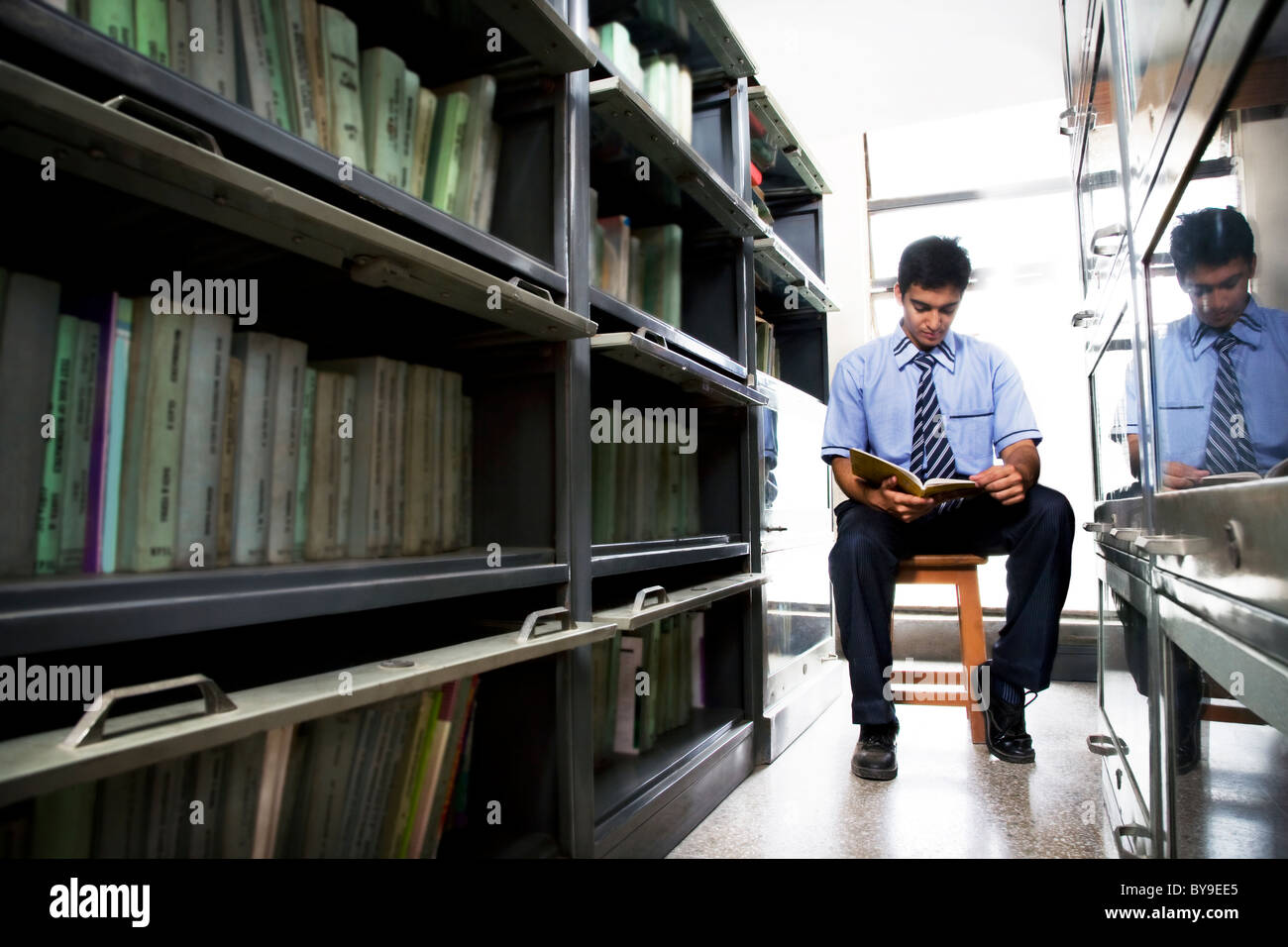 Boy reading a book in a school library Stock Photo - Alamy