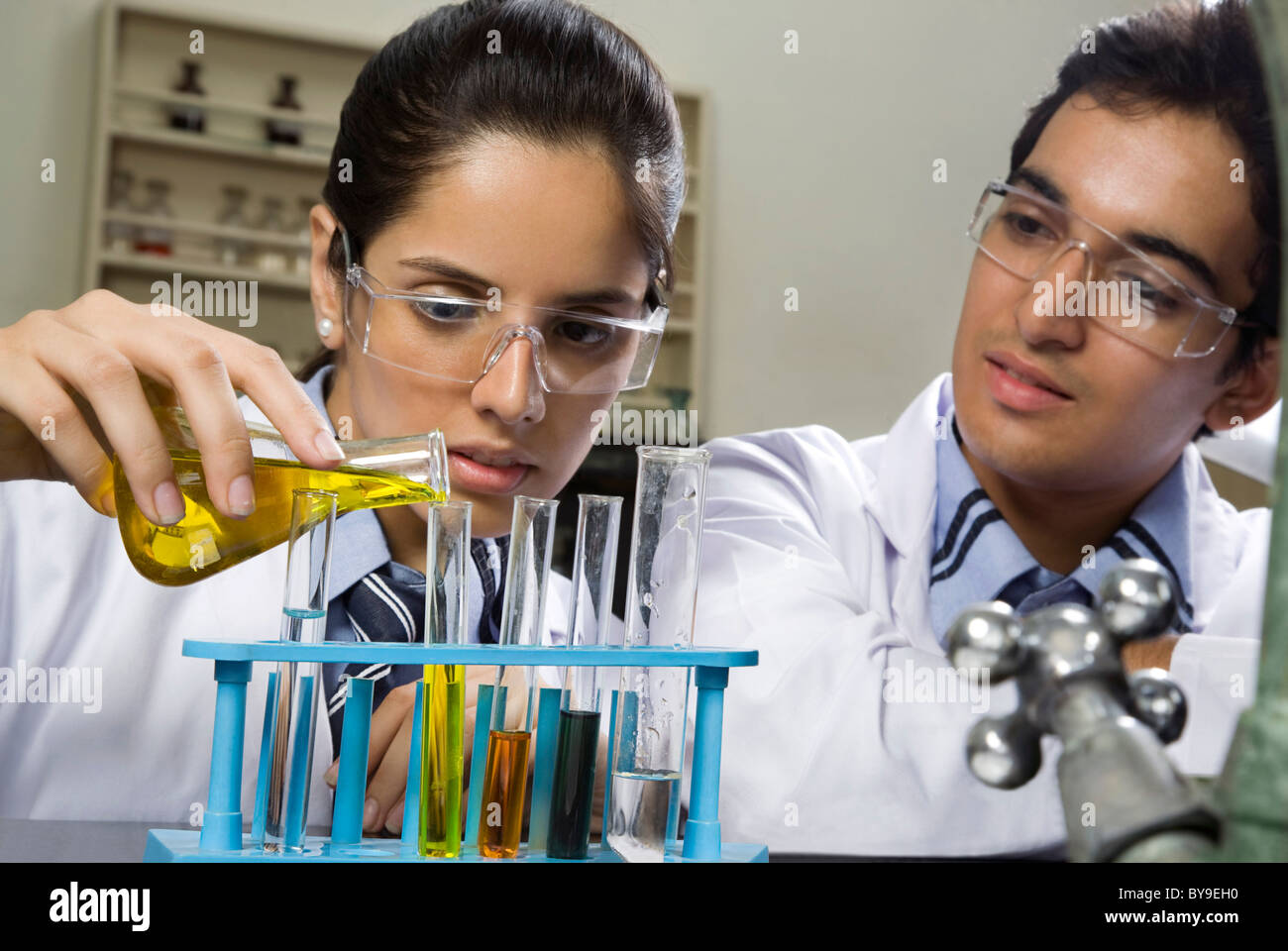 Girl pouring a liquid into a test tube Stock Photo - Alamy