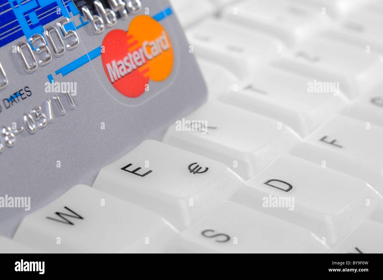 Credit card standing on a computer keyboard, symbolic image for ...