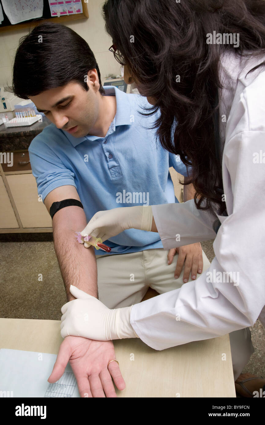 Doctor taking a blood sample from a man Stock Photo - Alamy