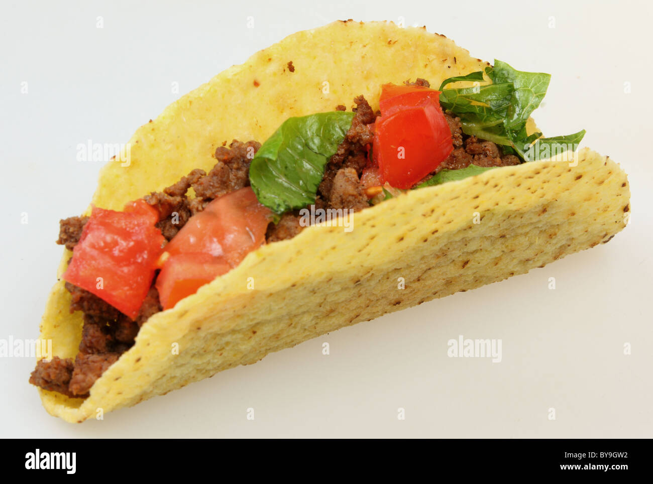 A taco shell and minced beef filling isolated over a plain background ...
