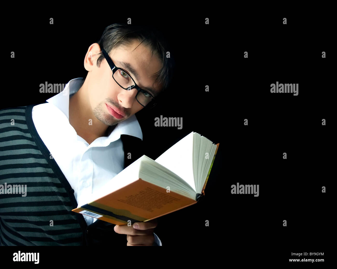 young man with the book on a black background Stock Photo - Alamy