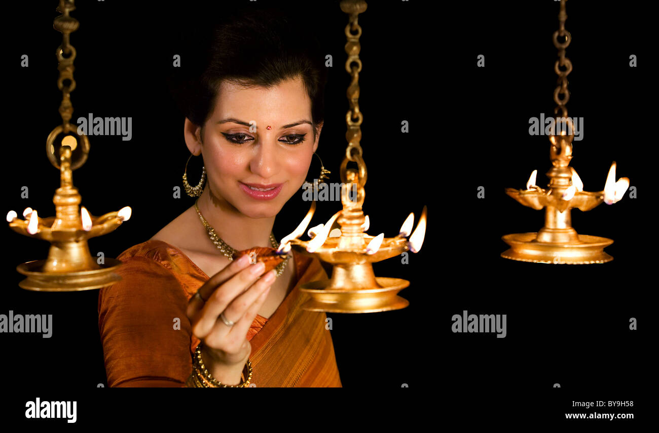 Traditional indian woman lighting diya hi-res stock photography and ...