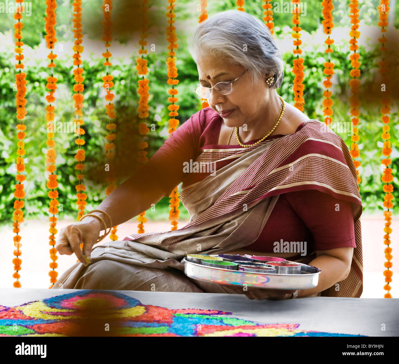 Old woman making a rangoli Stock Photo - Alamy
