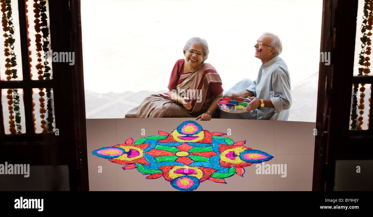 Old couple making a rangoli Stock Photo - Alamy